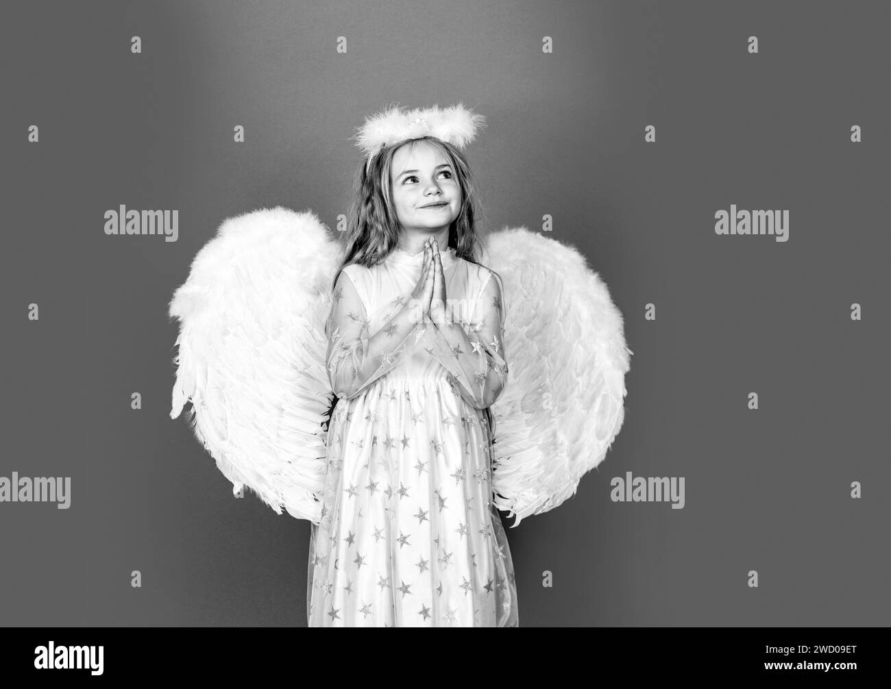 Child angel prayer. Child with angelic character. Toddler girl wearing ...