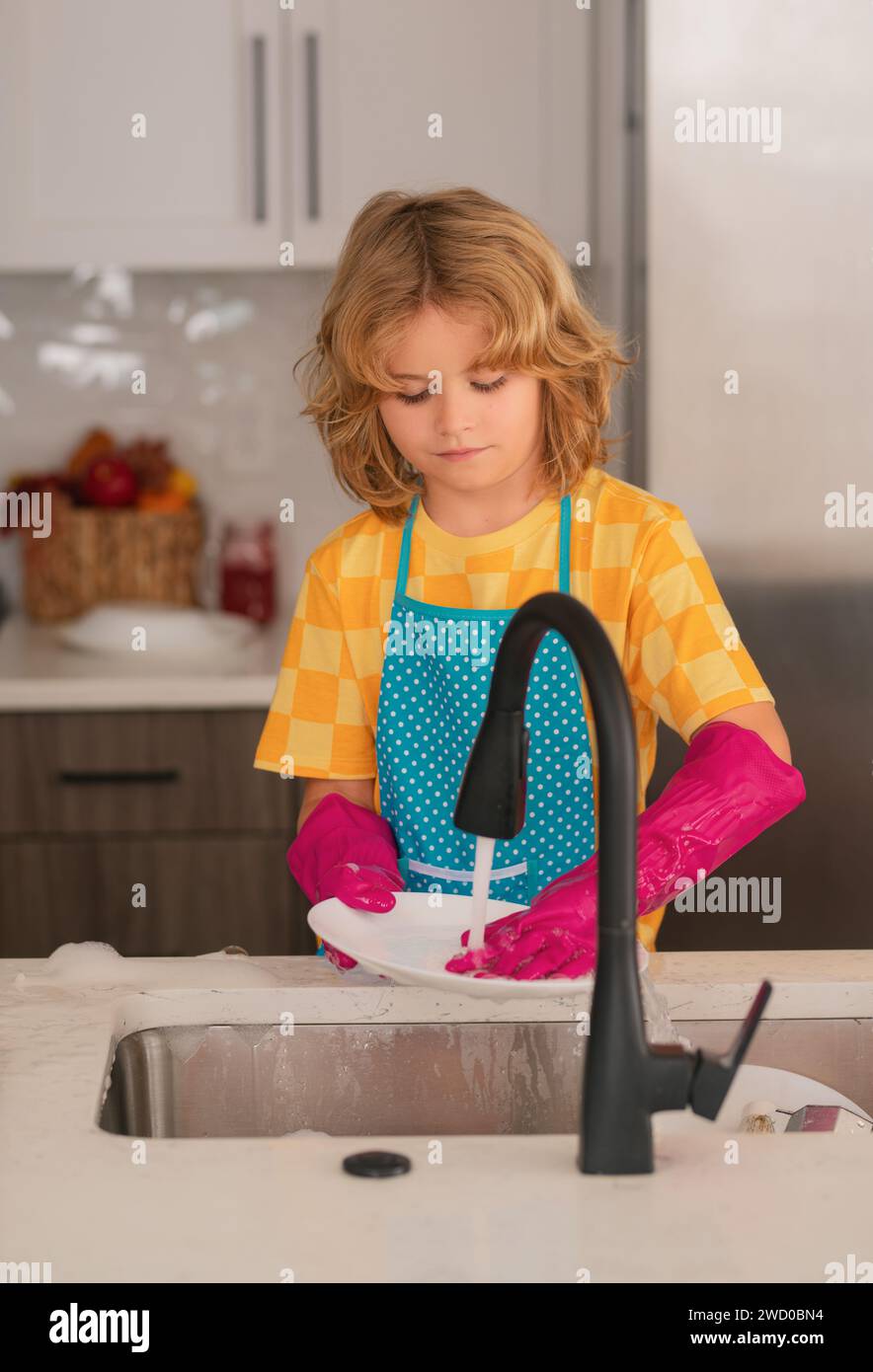 Cleaning at home. Kid washing dishes in the kitchen interior. Child ...