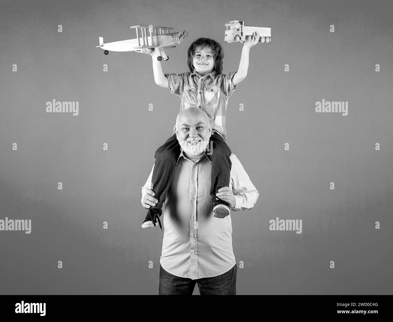 Child boy and grandfather playing piggyback ride with plane and wooden ...