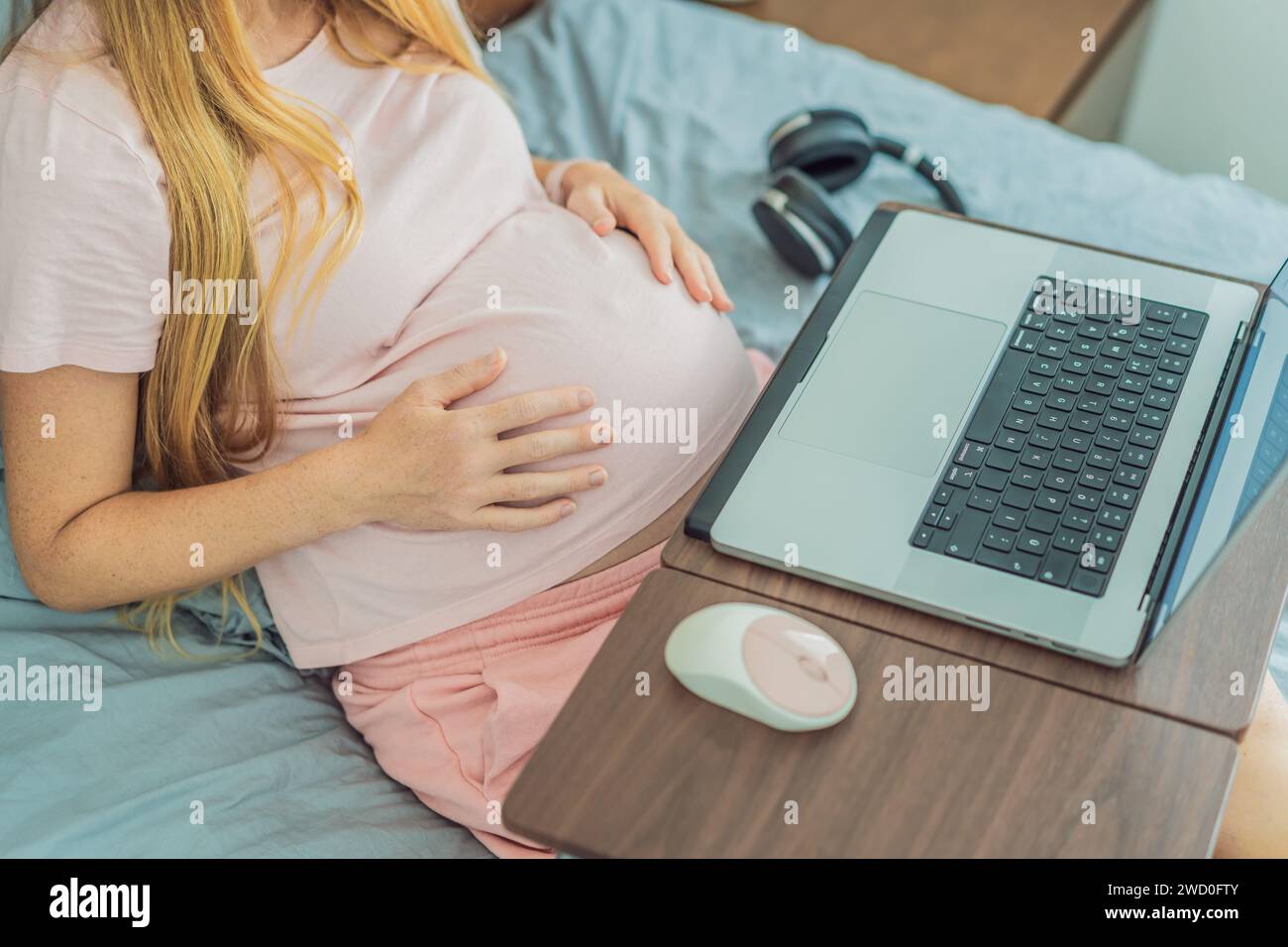 Pregnant woman working on laptop. Expectant woman efficiently works ...