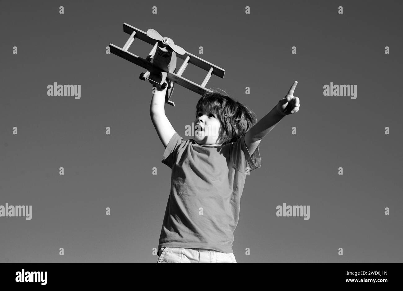 Kid pilot with toy airplane against sky background. Happy child playing ...