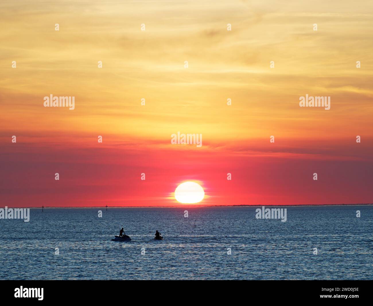 View of a spectacular vivid red sunset over the sea and horizon as seen ...