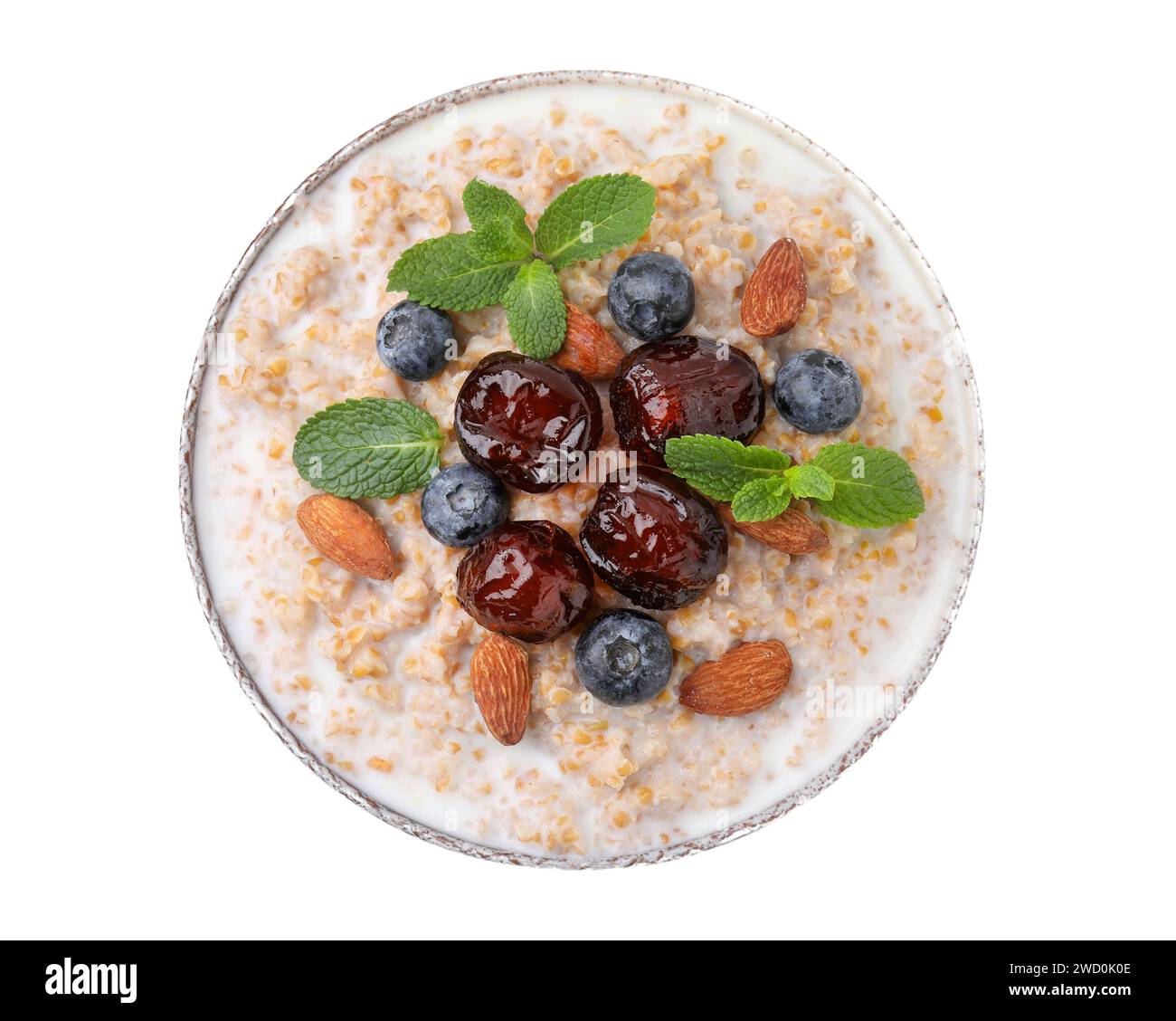 Tasty wheat porridge with milk, dates, blueberries and almonds in bowl ...