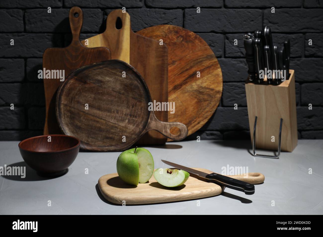 Wooden cutting boards, cut apple and knives on gray table Stock Photo ...