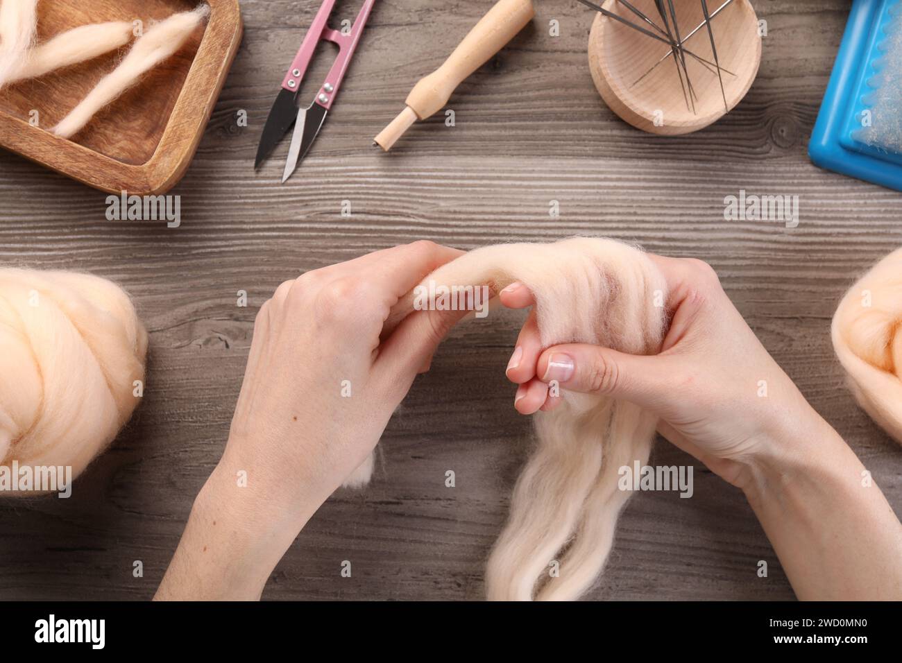 Woman felting from wool at wooden table, top view Stock Photo - Alamy