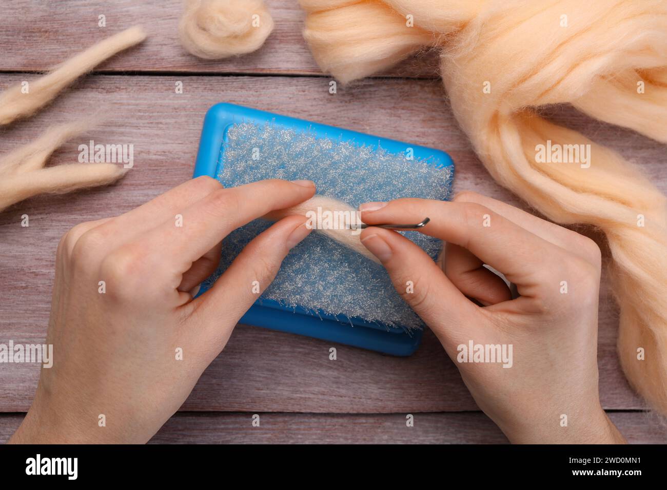 Woman felting from wool at wooden table, top view Stock Photo - Alamy