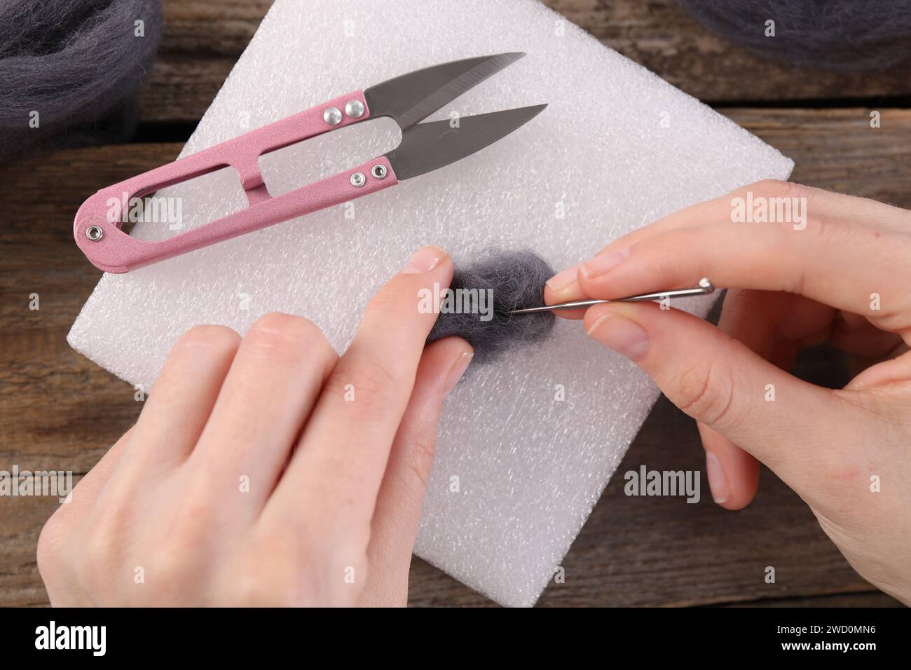 Woman felting from wool at wooden table, top view Stock Photo - Alamy