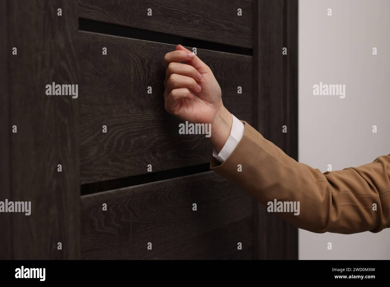 Collector knocking on door indoors, closeup view Stock Photo - Alamy