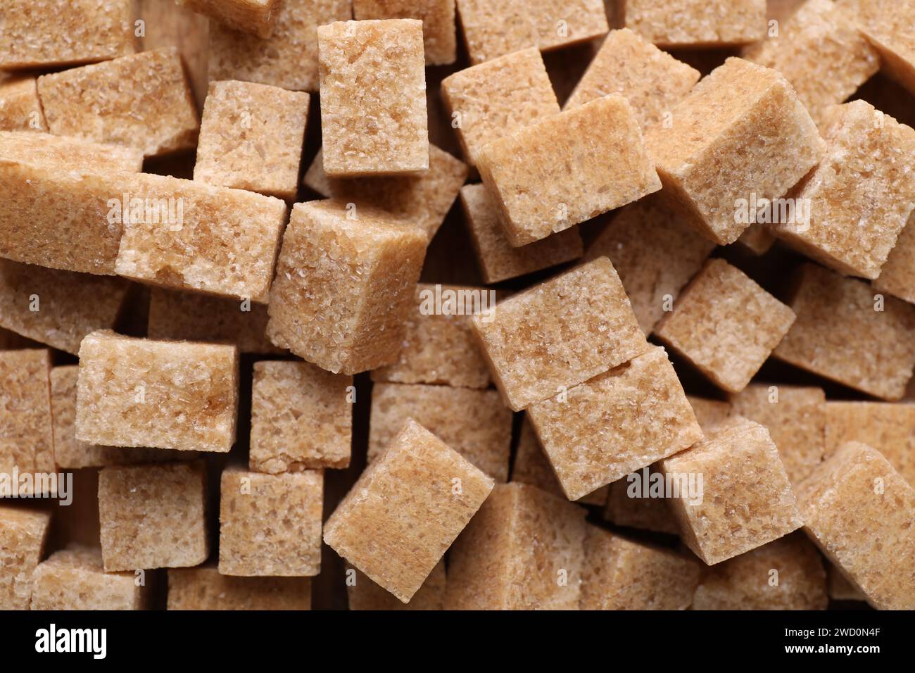 Different types of brown sugar as background, top view Stock Photo - Alamy