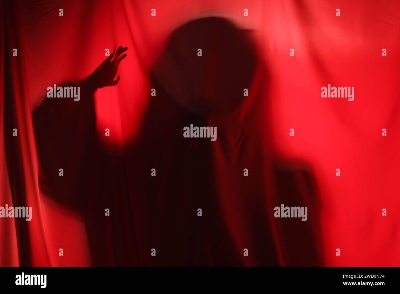 Silhouette of creepy ghost behind red cloth Stock Photo - Alamy