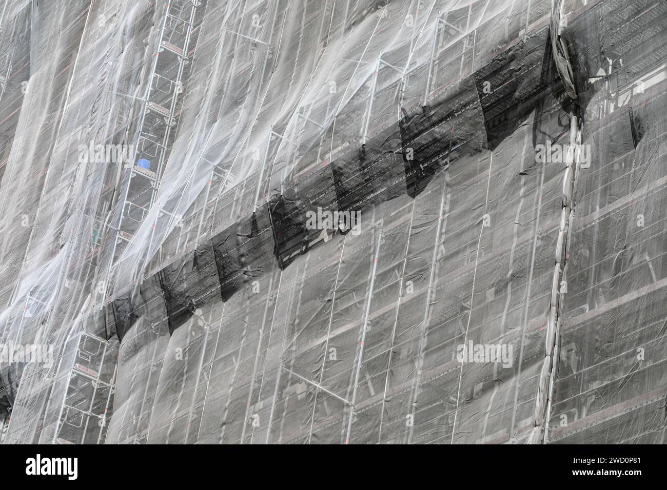 Scaffolding with safety mesh at a construction site Stock Photo - Alamy