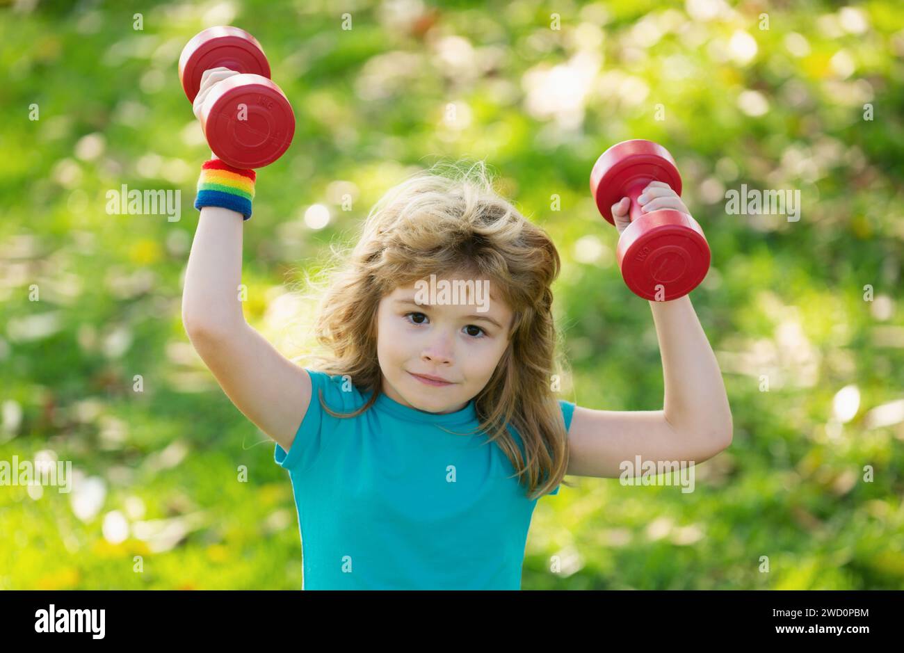 Kids sport. Boy is doing exercises to develop muscles. Child is doing ...