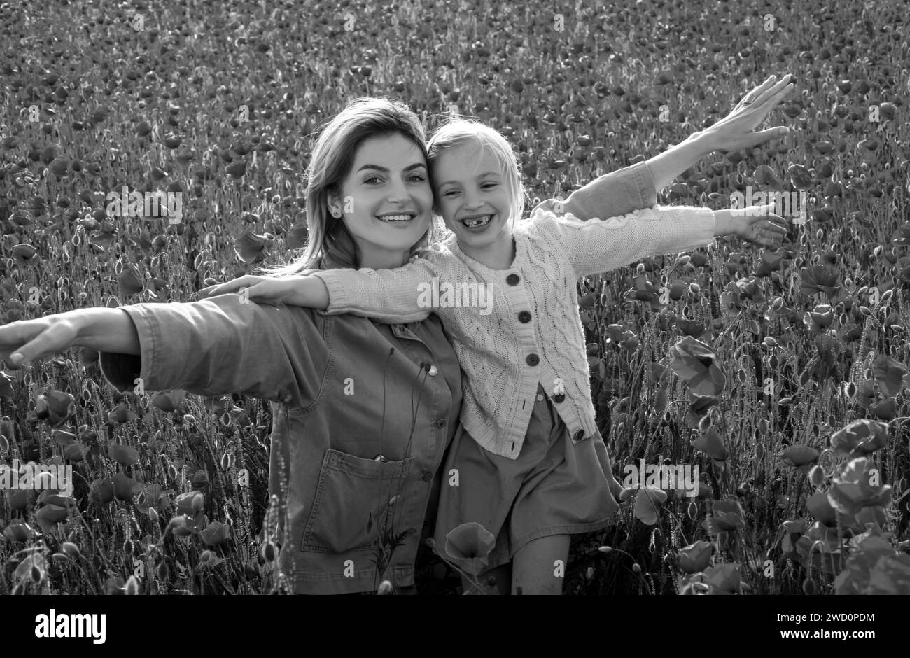 Mother with daughter outdoor in poppy field. Carefree mom and lovely ...