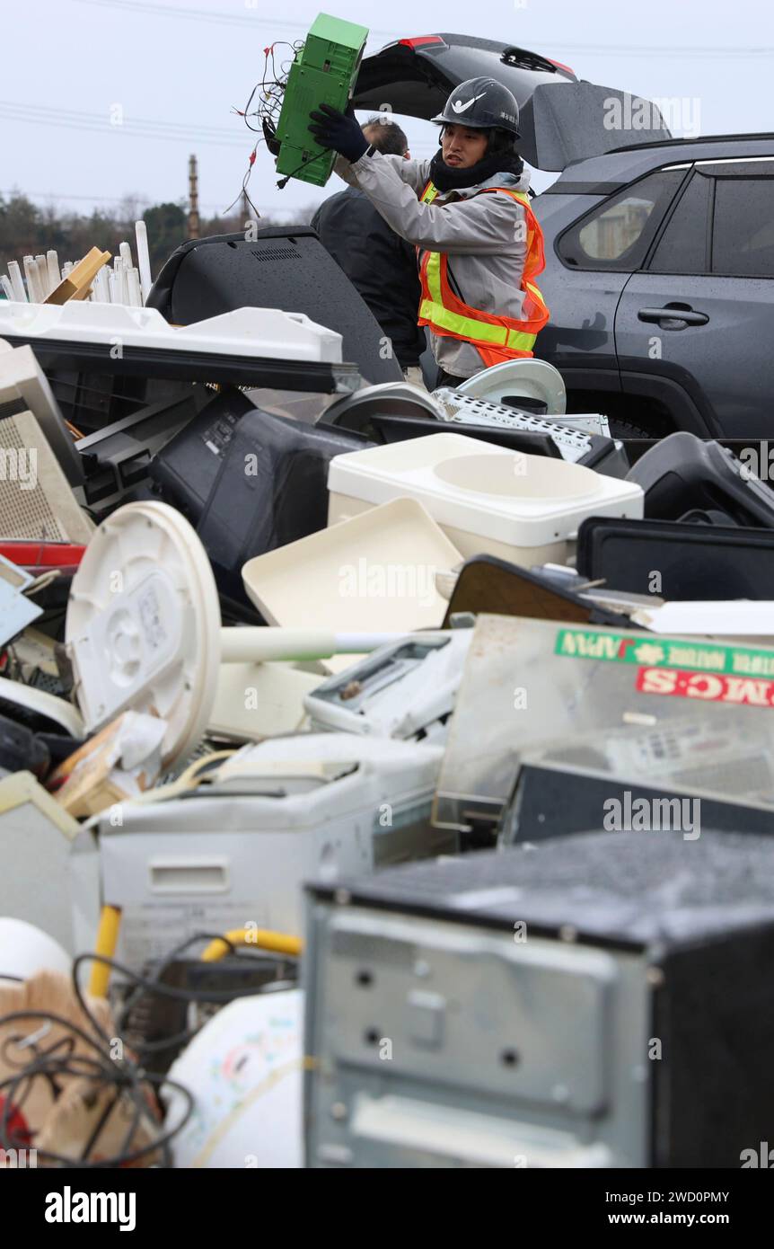 Disaster wastes are piled up at a parking area used as a temporary ...