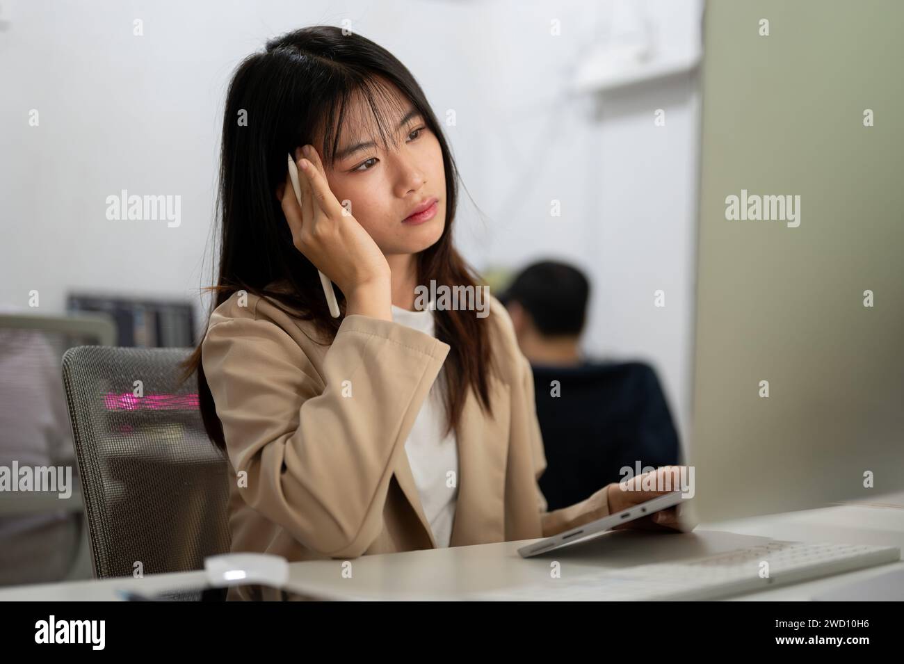 A tired and overworked young Asian businesswoman or female office ...