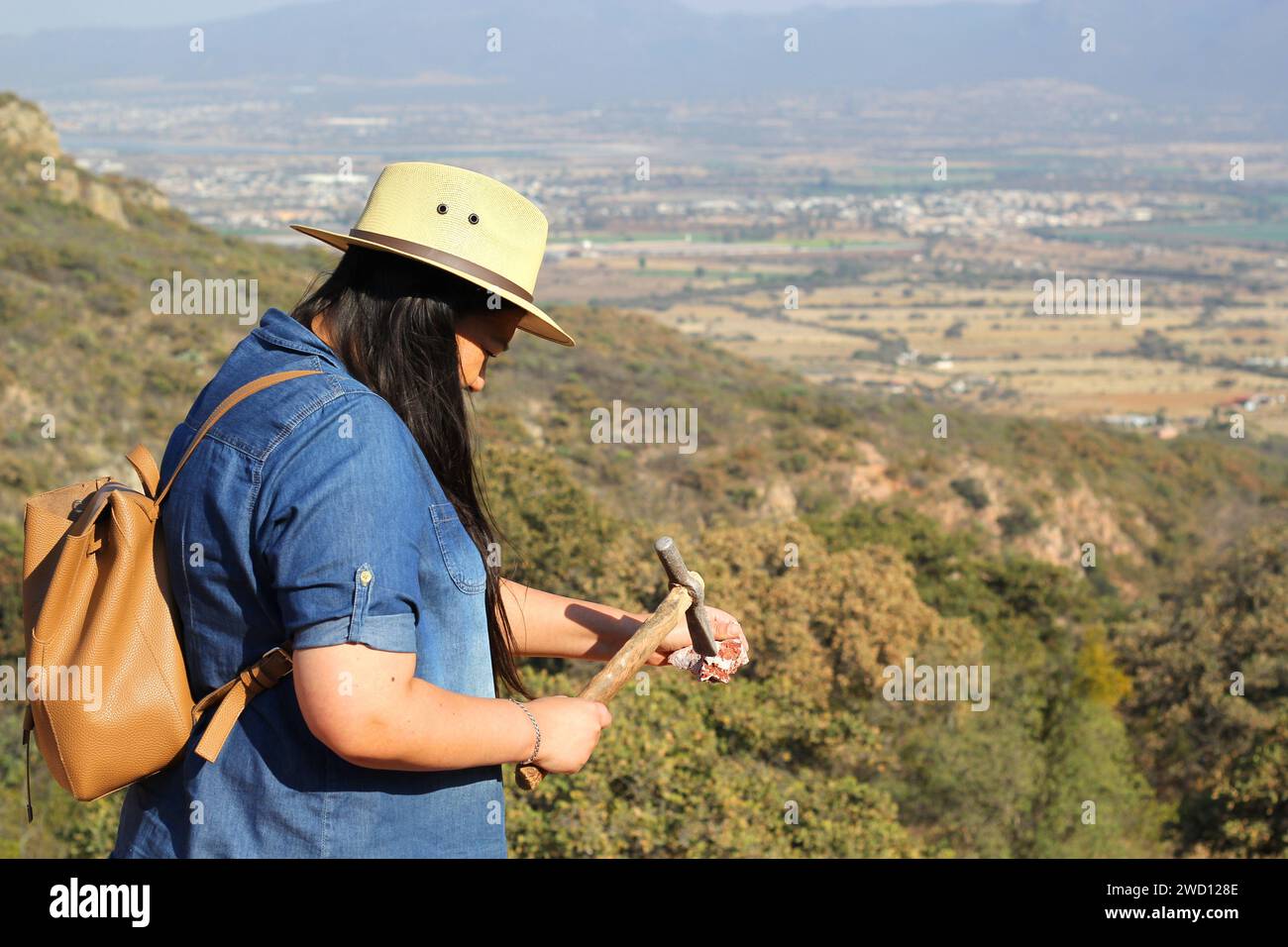 Latin adult woman geologist studies the details and characteristics of ...