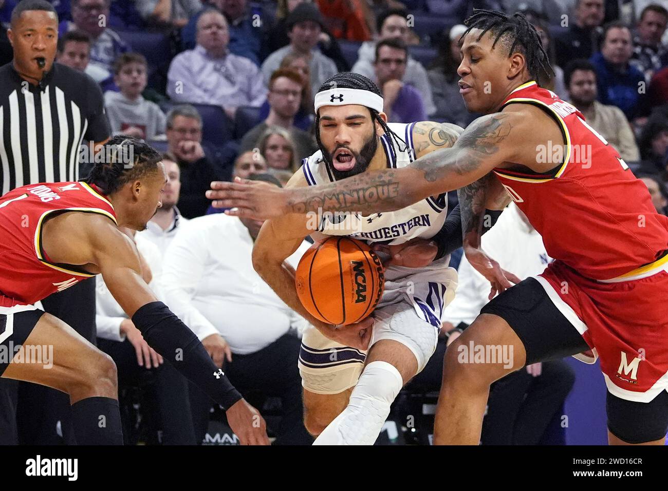 Northwestern guard Boo Buie, center, drives as Maryland guard Jahmir ...