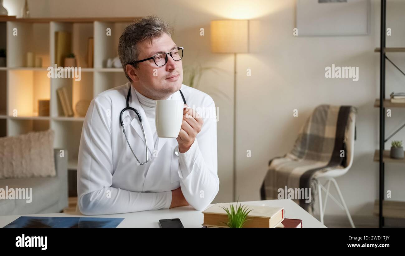 Doctor relaxing coffee break man cup workplace Stock Photo - Alamy