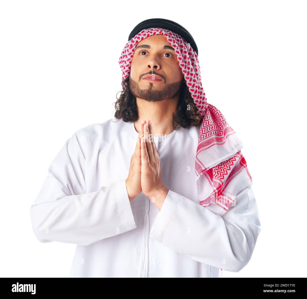 Young Arab man in traditional clothing praying on white background ...