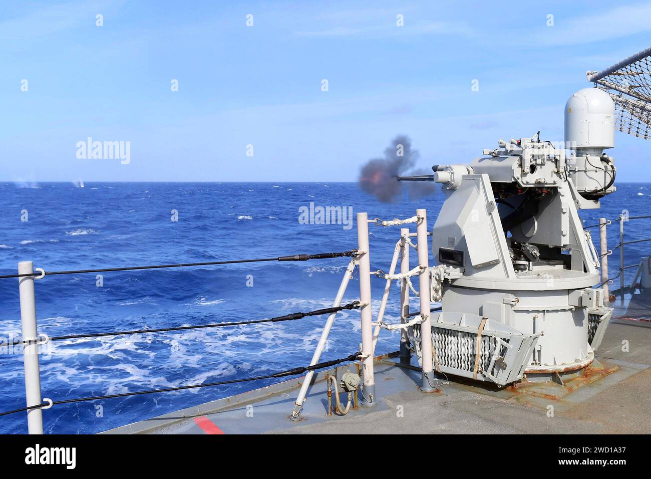 An MK-38 25mm machine gun being fired aboard guided-missile cruiser USS ...