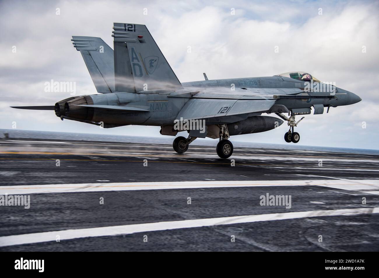 An F/A-18E Super Hornet conducts a touch-and-go landing aboard USS ...