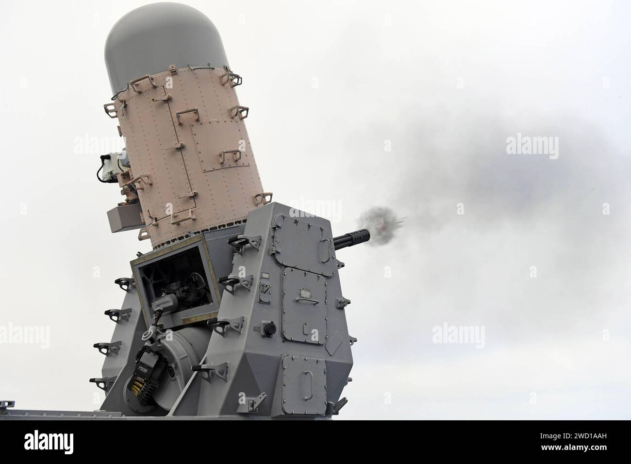 A Phalanx close-in weapons system firing rounds aboard the USS Hue City ...