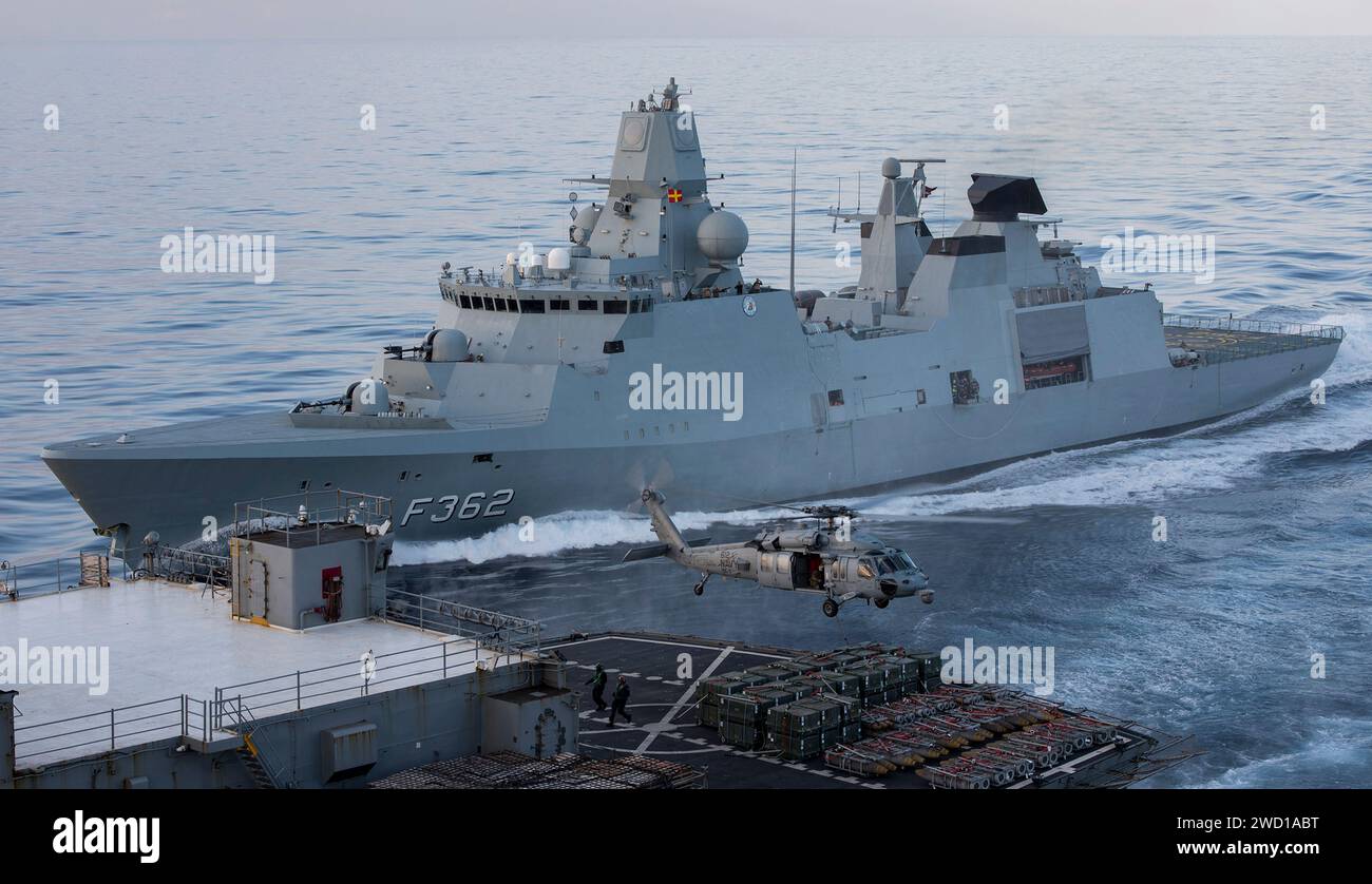 An MH-60S Sea Hawk lifts cargo from USNS Supply during a replenishment ...
