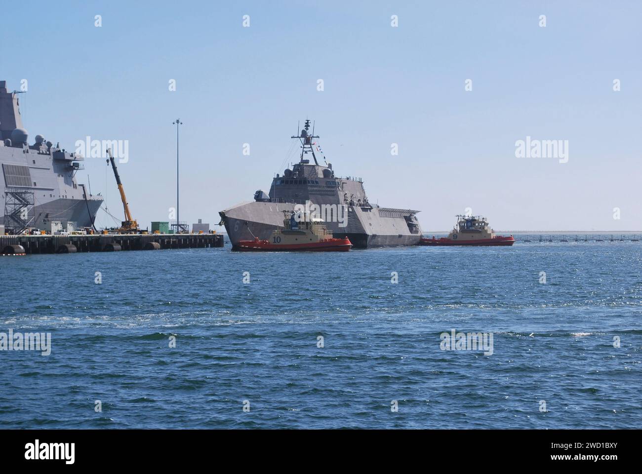 Tug boats moor the Independence-variant littoral combat ship USS ...