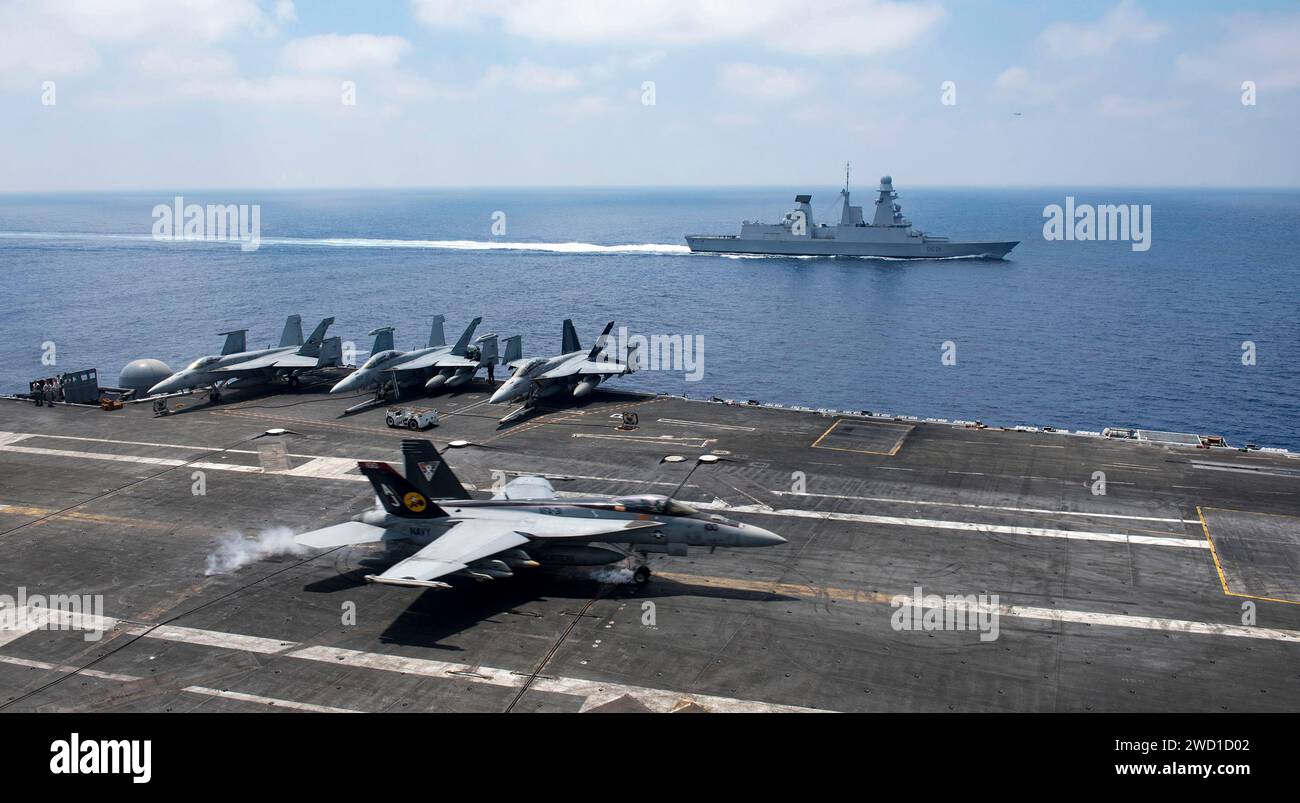 The French Navy frigate FS Chevalier Paul sails alongside USS George H.W. Bush as an F/A-18E ...