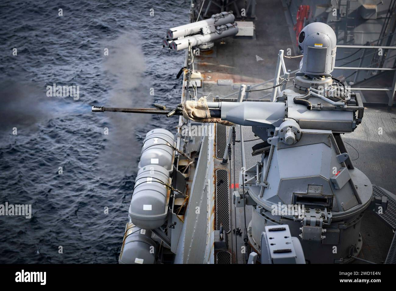 The guided-missile destroyer USS Oscar Austin fires its Mark 38 25mm ...