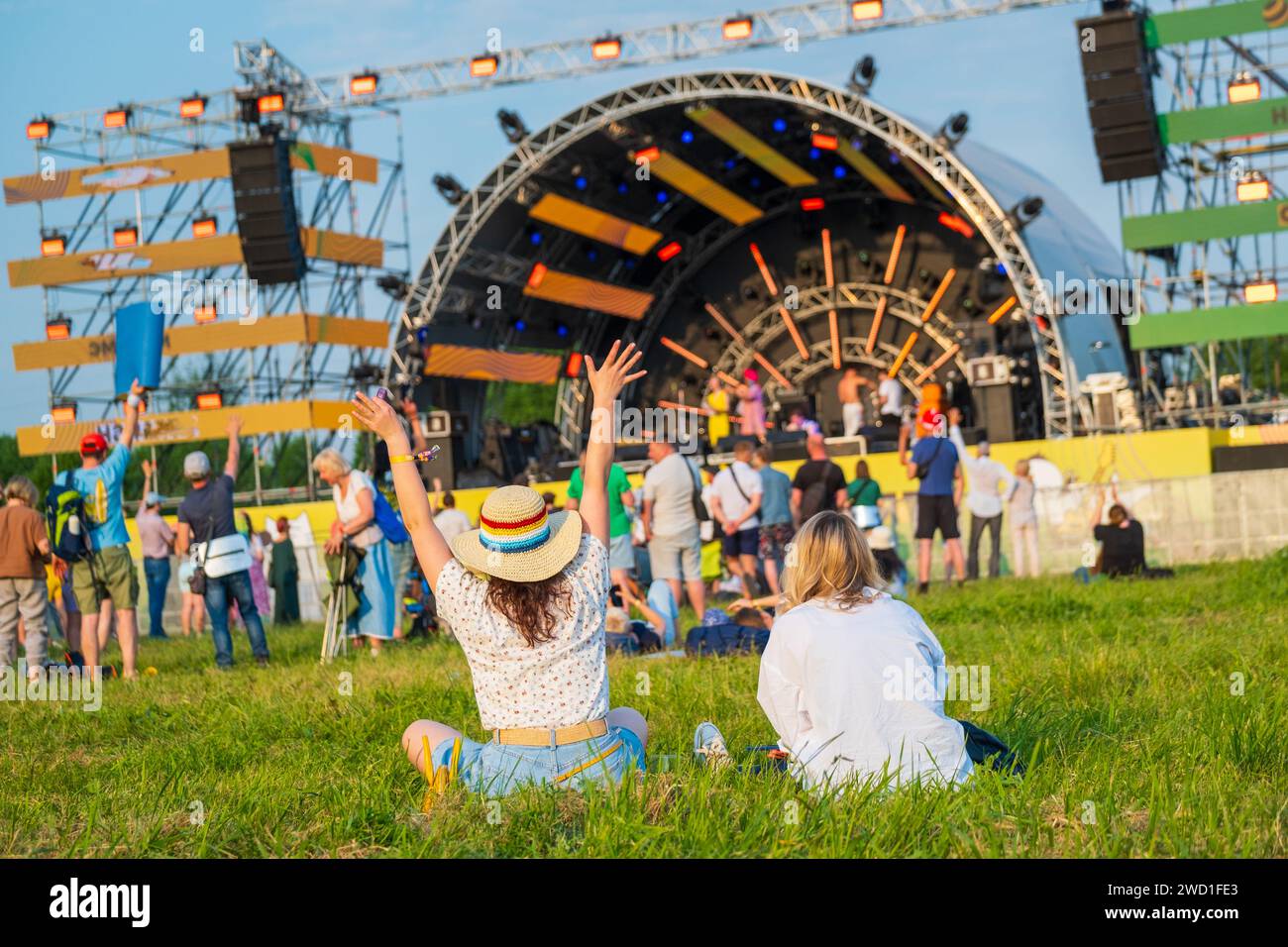 Rear view of people having fun at a summer music festival, enjoying ...