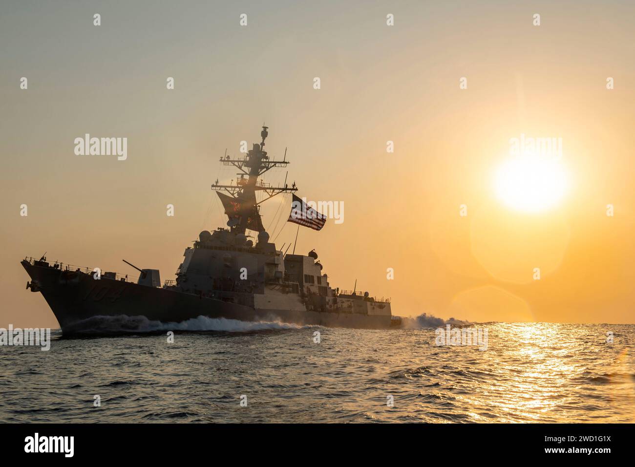 The guided-missile destroyer USS Sterett steams with its Battle Ensign ...