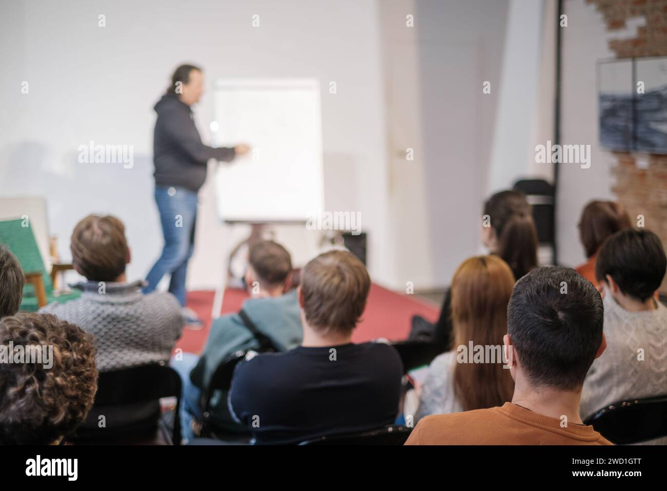 Audience attentively listening to a presenter at a workshop with focus ...