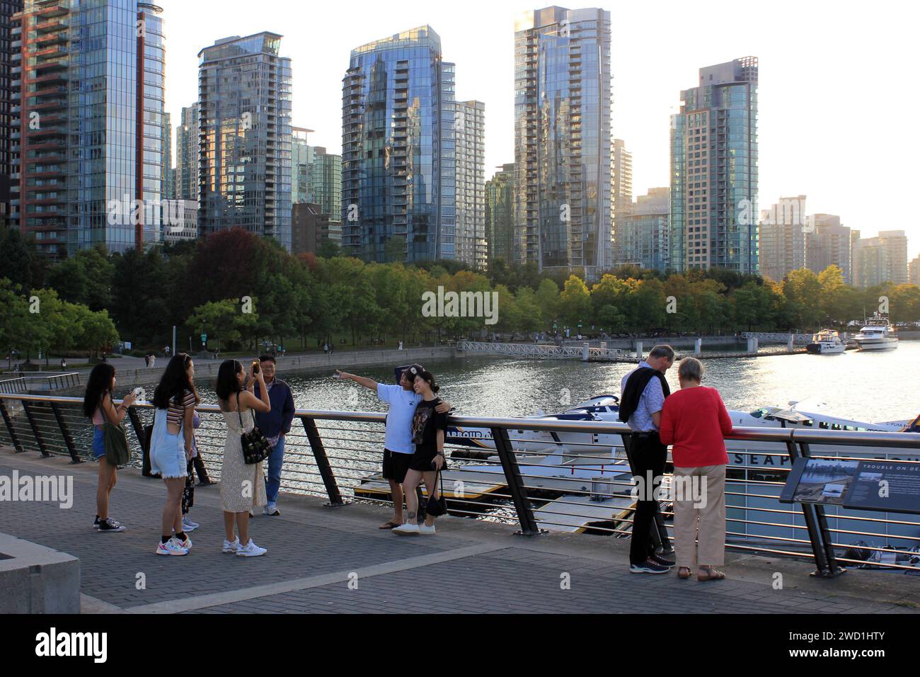 A group of people standing at the seawall of Vancouver downtown ...