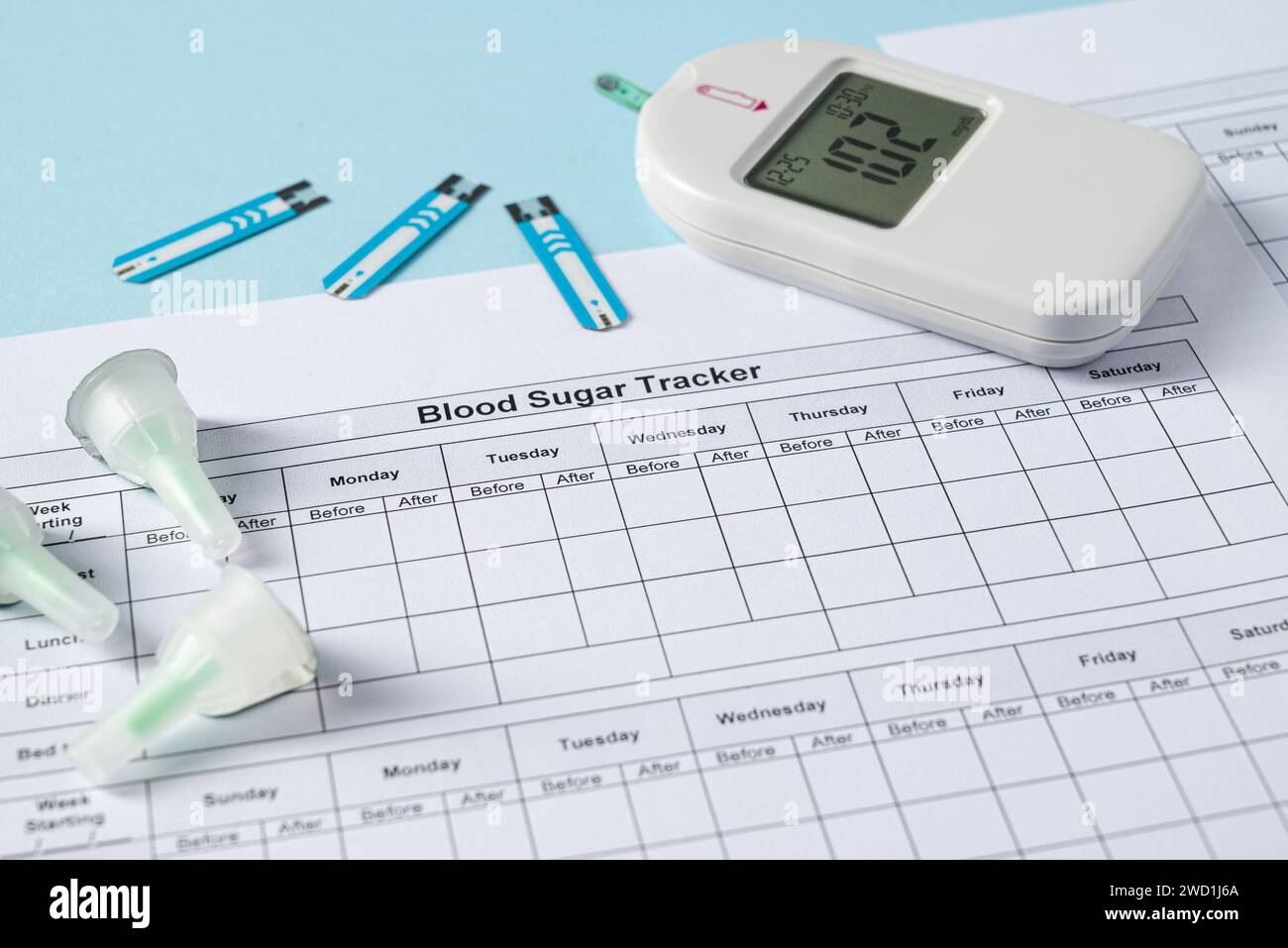 Top view of glucometer, lancet pen, strips and blood sugar tracker on ...