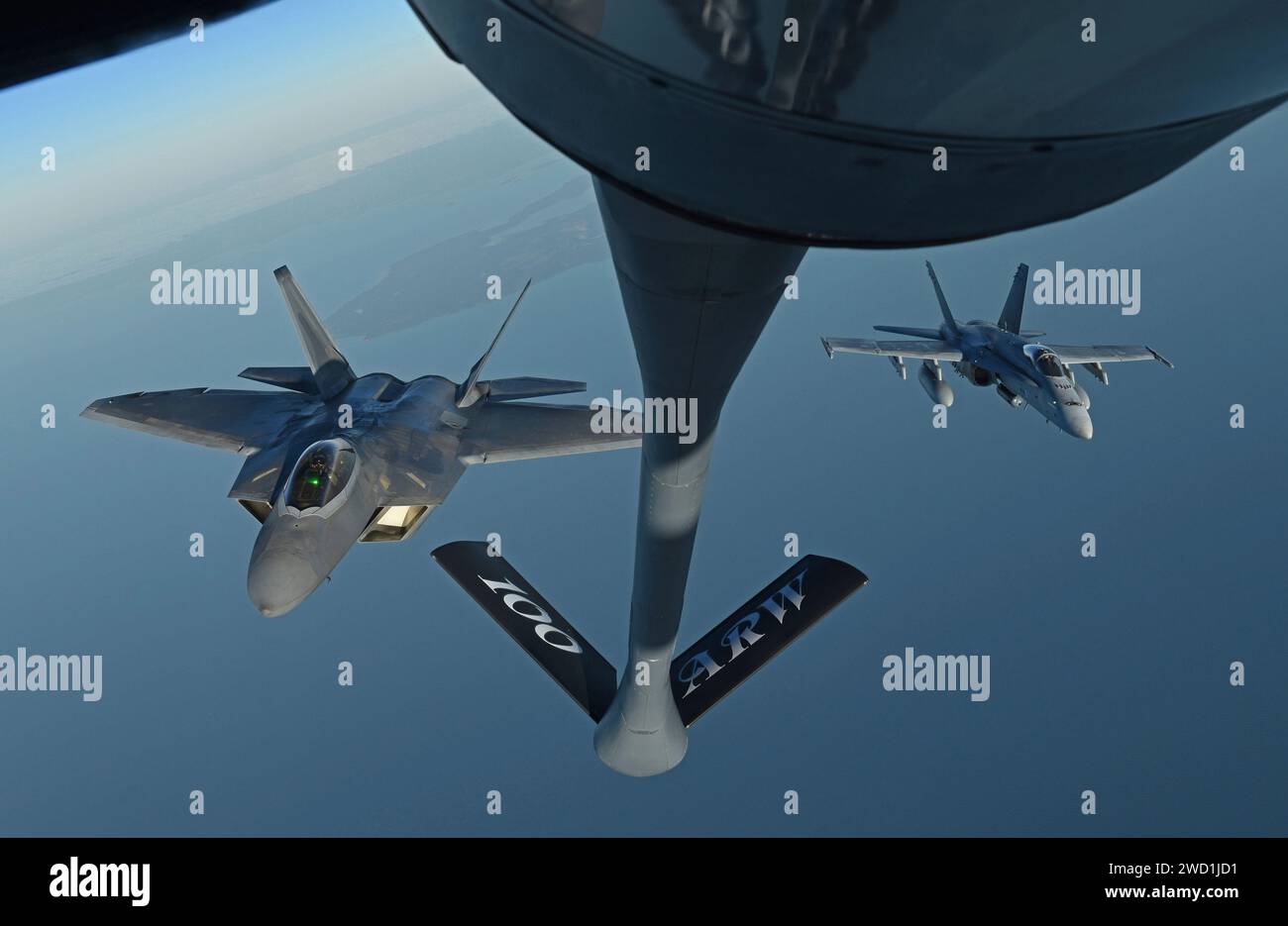 A U.S. Air Force F-22 Raptor and a Finnish Air Force F/A-18 Hornet fly ...