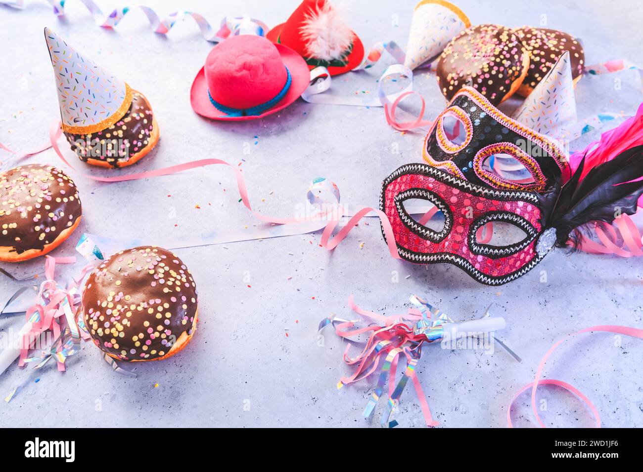 Carnival food. German Krapfen or donuts with streamers and confetti ...