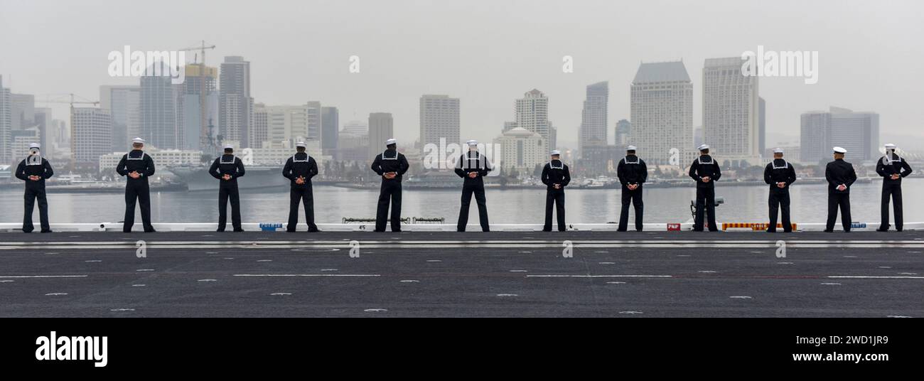 Sailors aboard the aircraft carrier USS Carl Vinson man the rails as ...