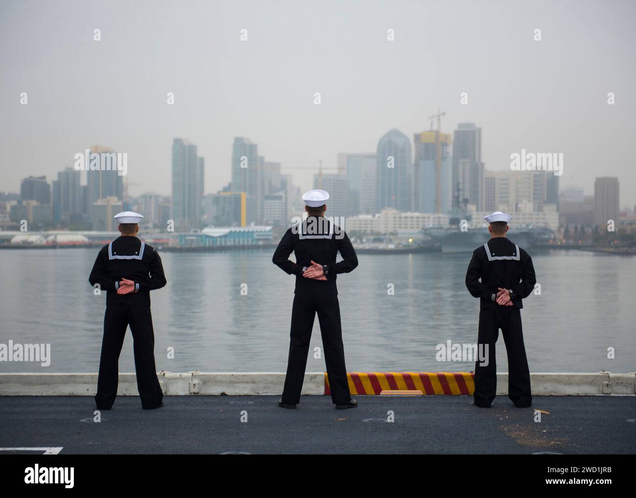 Sailors aboard the aircraft carrier USS Carl Vinson man the rails as ...