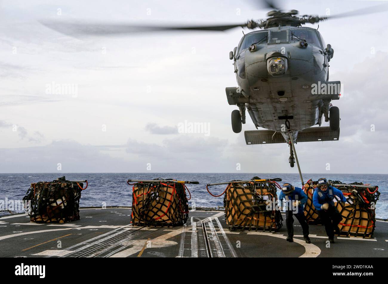Sailors connecting cargo to an MH-60S Sea Hawk helicopter on the flight ...