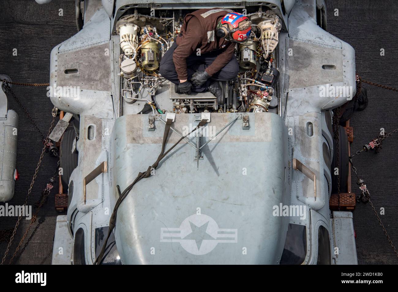 Naval Air Crewman performs maintenance on an MH-60S Sea Hawk helicopter ...
