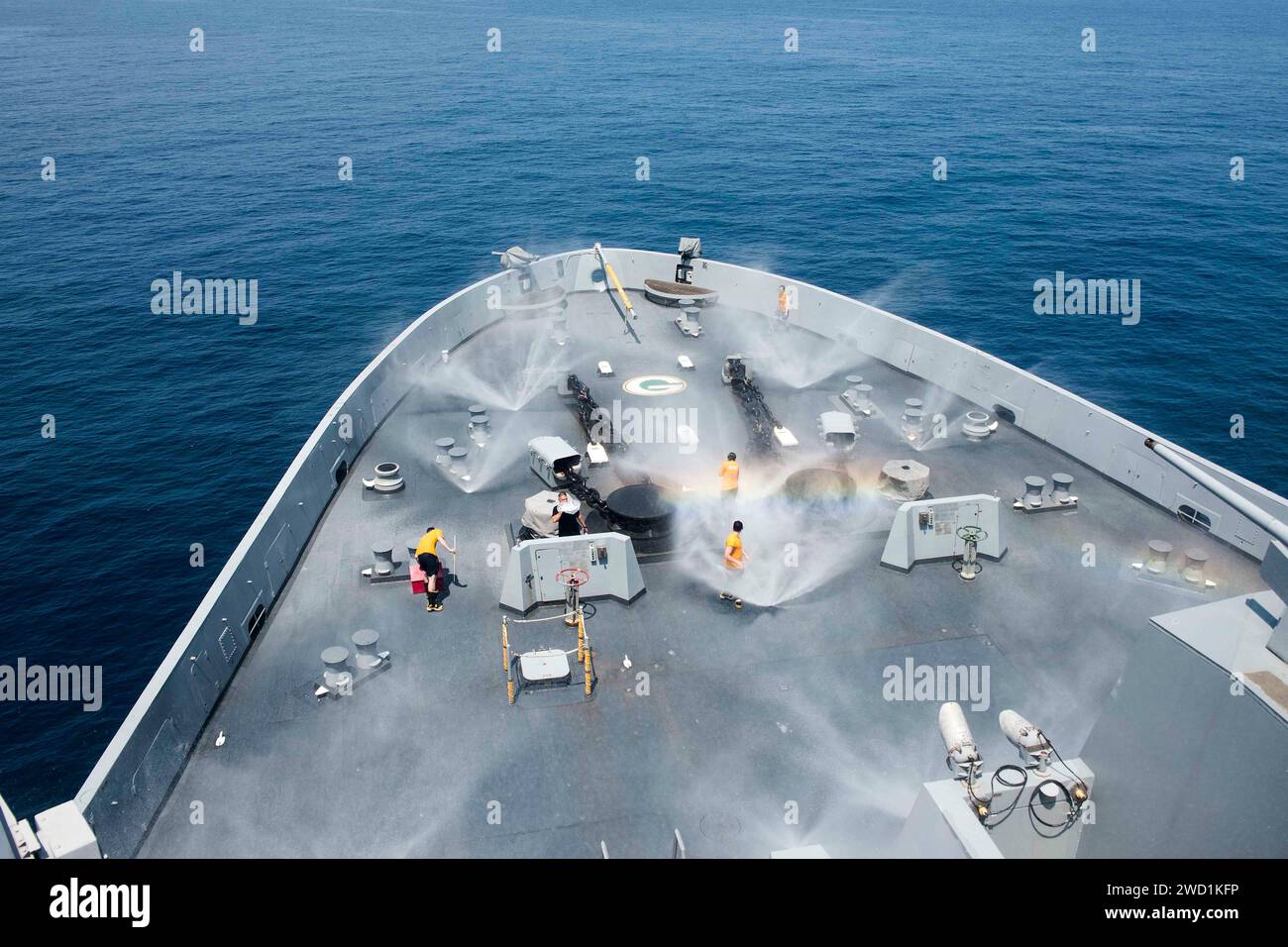 Sailors conduct a countermeasure wash-down on the forecastle of USS ...