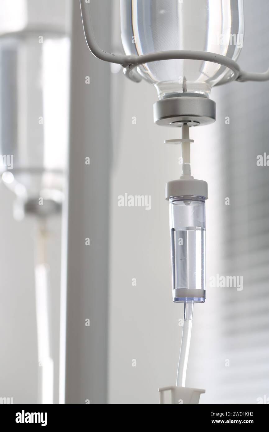 IV drip chamber against blurred light background Stock Photo - Alamy