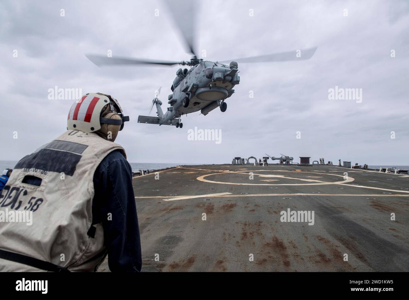 An MH-60R Sea Hawk helicopter prepares to land on the flight deck of ...