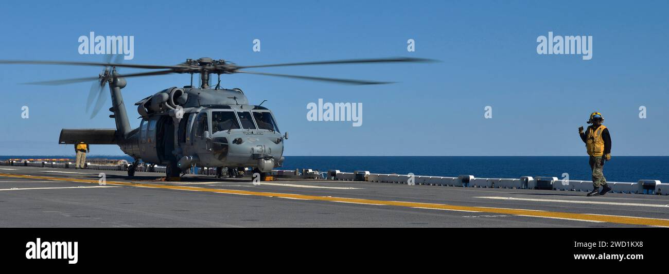 An MH-60 Sea Hawk helicopter prepares to take off from the amphibious ...