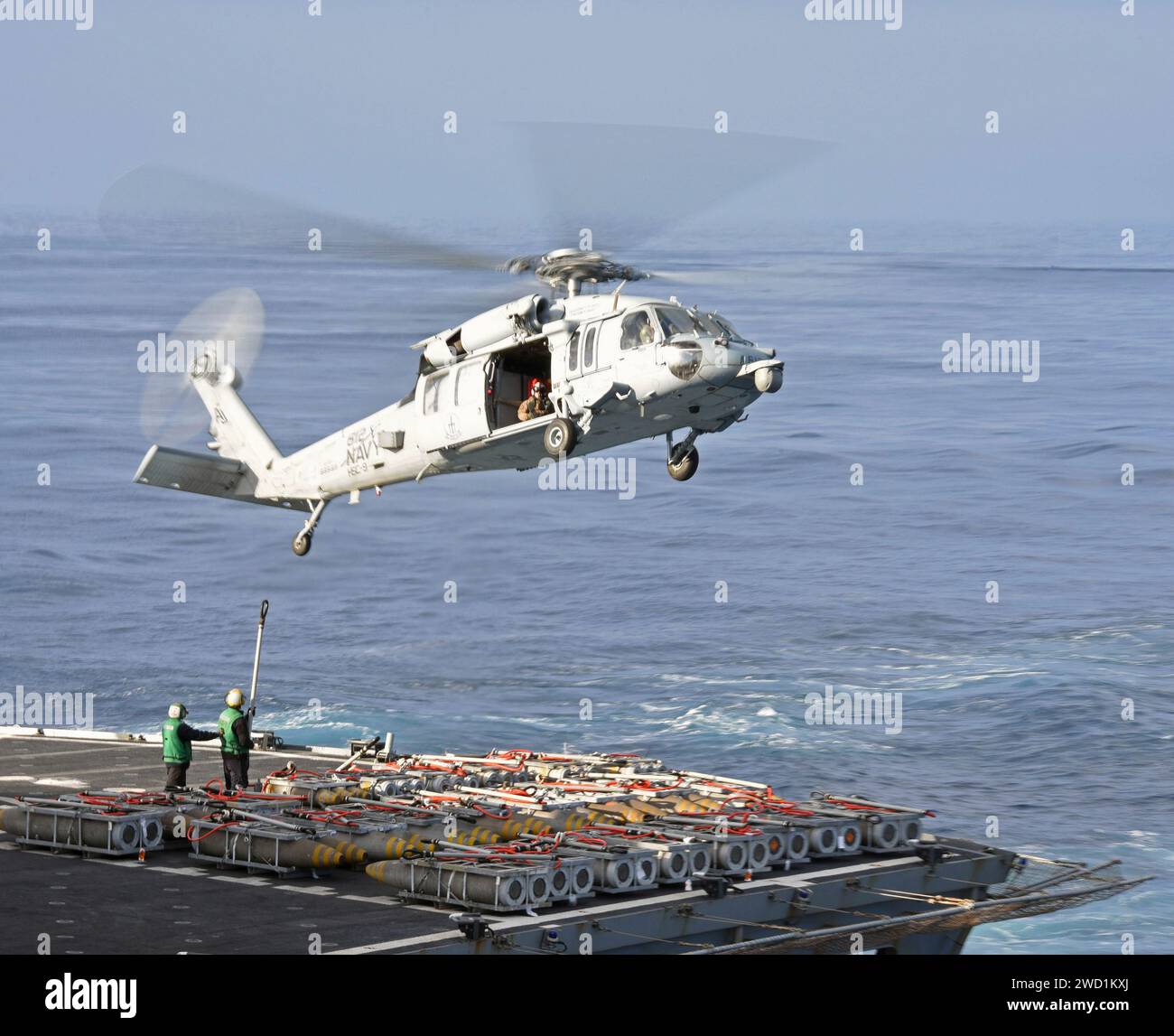 An MH-60S Sea Hawk helicopter picks up cargo from USNS Supply during a ...