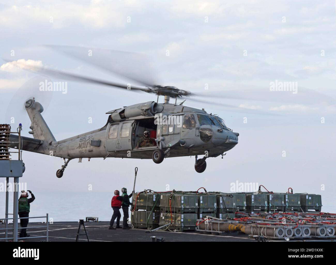 An MH-60S Sea Hawk helicopter picks up cargo from USNS Supply during a ...