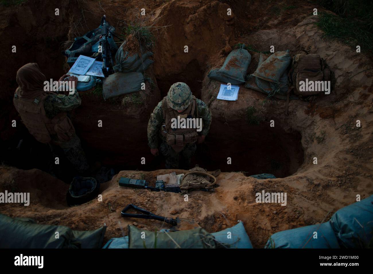 Seabees stand inside their fighting position during a field training ...
