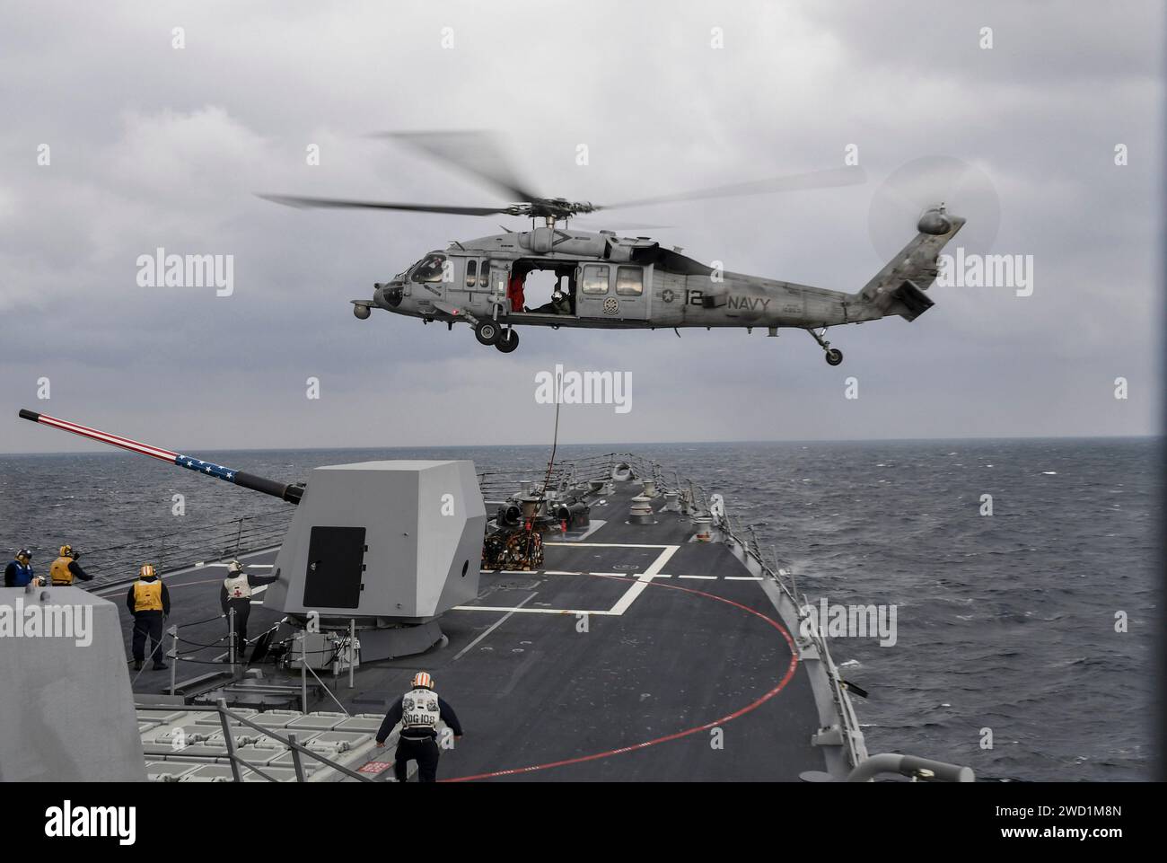 An MH-60S Sea Hawk helicopter delivers cargo onto the forecastle of USS ...
