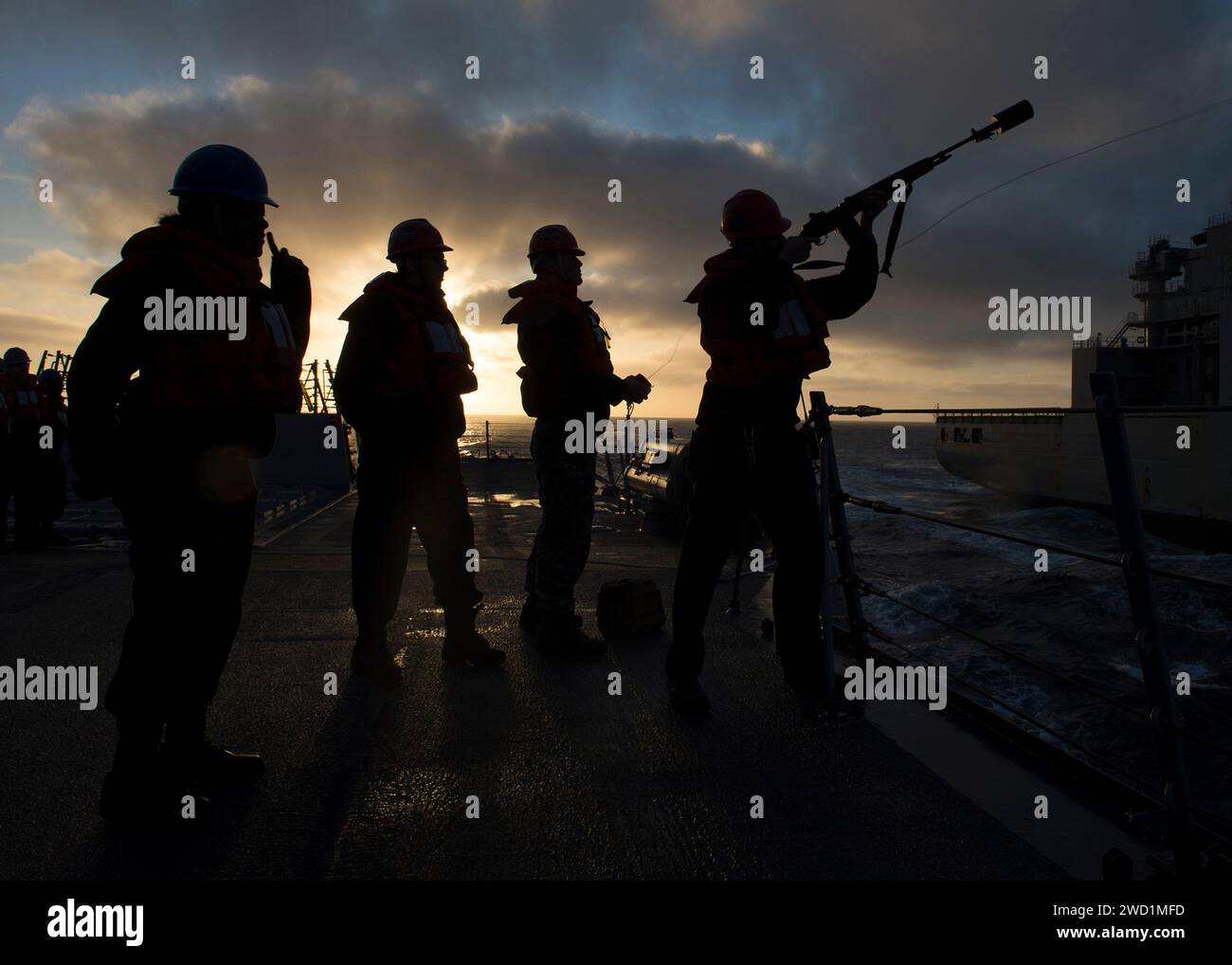 Gunner's Mate fires a shot line aboard USS Pinckney during a ...